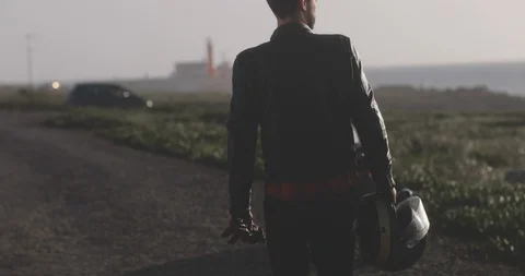 Back view of man getting on motorcycle b... | Stock Video | Pond5