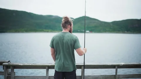 Back View Of A Man Holding Fishing Rod B... | Stock Video | Pond5