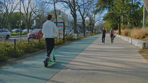 Back view of man rides an electric scoot... | Stock Video | Pond5