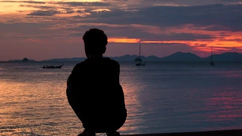 Back view of teen boy silhouette sitting... | Stock Video | Pond5