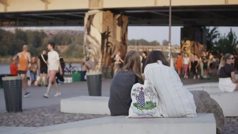 Back view of Two girls sit on outdoor an... | Stock Video | Pond5