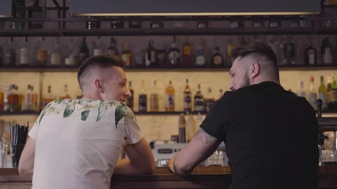 Back view of two men sitting at the bar ... | Stock Video | Pond5