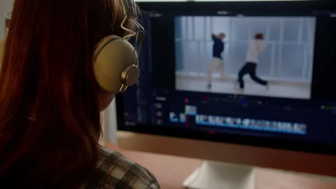 Back view of video editor in headphones ... | Stock Video | Pond5