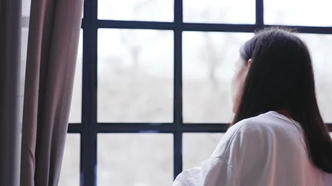 Back view of a woman looking outside thr... | Stock Video | Pond5