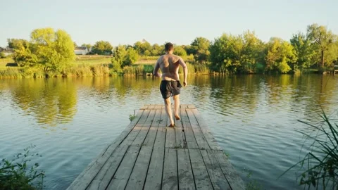 Back view of a young guy jumping from a ... | Stock Video | Pond5