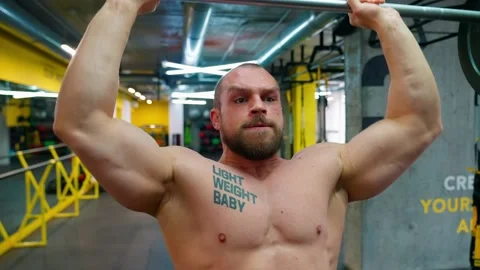 Bald bodybuilder exercising in the gym. ... | Stock Video | Pond5