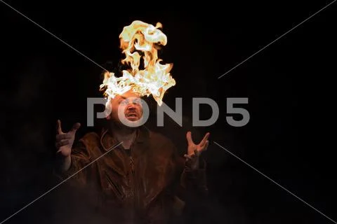 Bald man in a leather jacket with a burning head on a dark background ...