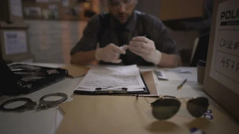 Ballistics officer comparing bullet size... | Stock Video | Pond5