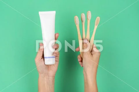 Bamboo toothbrushes and a tube of toothpaste in female hands ~ Premium ...