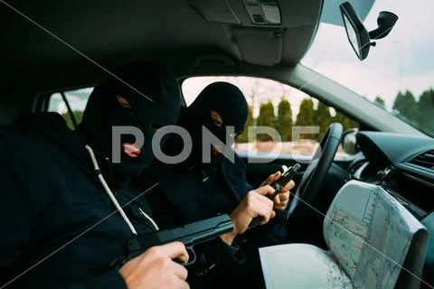Bank robbers with their masks on pointing at the map prepared for ...