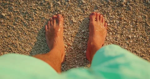 Bare feet man standing on wet pebbles at... | Stock Video | Pond5