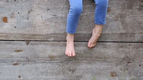 Bare feet of a small peasant child sitti... | Stock Video | Pond5