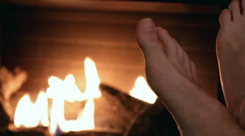 Bare feet warmed in front of fire | Stock Video | Pond5