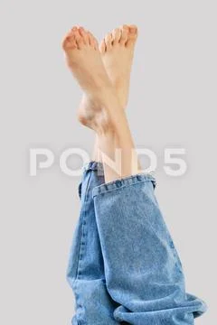 Bare female legs in boyfriend jean on grey background Stock Photo ...