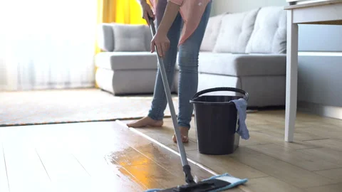 Barefoot girl mopping floor, maintaining... | Stock Video | Pond5
