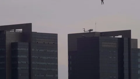 Base jumpers jumping from Menara tower i... | Stock Video | Pond5