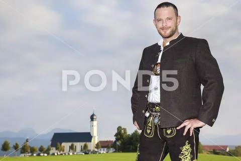 Bavarian tradition man with a church in the background ~ Hi Res #85816288