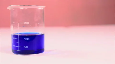 Beaker with blue liquid on white backgro... | Stock Video | Pond5