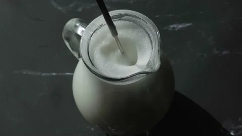Beat the milk in a mug using a frother. ... | Stock Video | Pond5