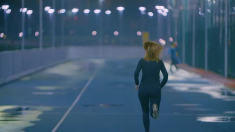 Beautiful blonde woman jogging at night ... | Stock Video | Pond5
