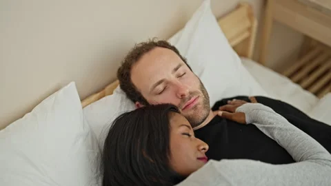 Beautiful couple lying on bed hugging ea... | Stock Video | Pond5