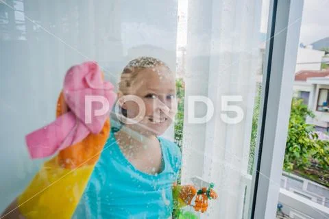 Beautiful female maid doing the housework while using a spray, washing ...