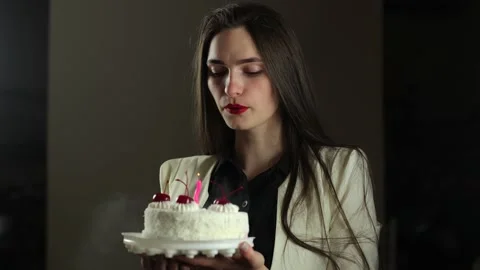 A beautiful girl with a cake in her hand... | Stock Video | Pond5