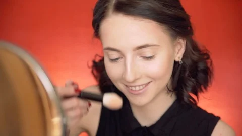 beautiful girl doing makeup on a red bac... | Stock Video | Pond5