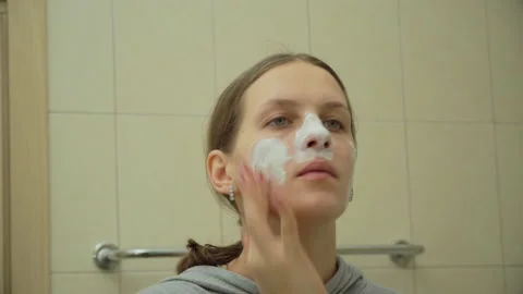 Beautiful Girl Smears a Mask on her Face | Stock Video | Pond5