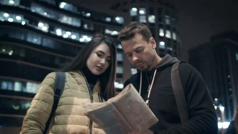 A beautiful girl is watching a map at ni... | Stock Video | Pond5