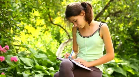 Beautiful girl writing into her diary | Stock Video | Pond5