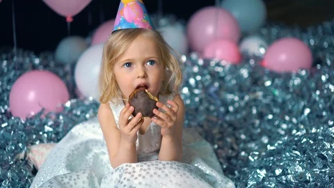 Beautiful happy little girl biting birth... | Stock Video | Pond5