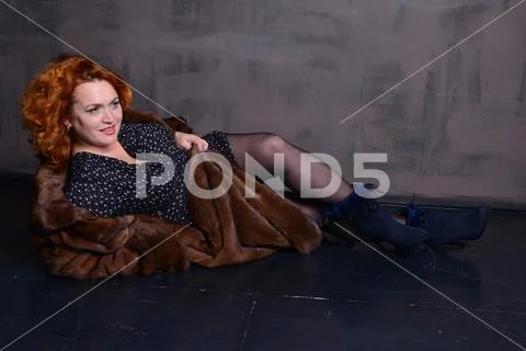 Photograph: Beautiful model dressed in fur laying on sofa Sexy woman ...