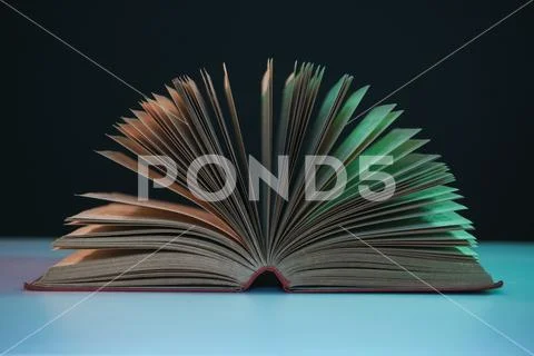 Photograph: Beautiful open book pages in the color neon light on a ...