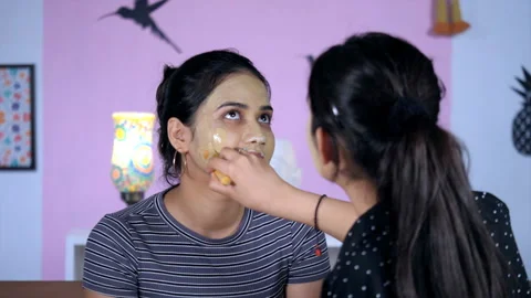 Beautiful teenage girl putting a face pa... | Stock Video | Pond5