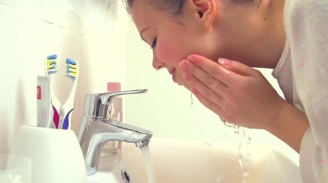 Beautiful teenage girl washing her face | Stock Video | Pond5