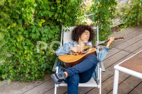 Beautiful young Afro-Italian mixed race man in casual wear playing ...