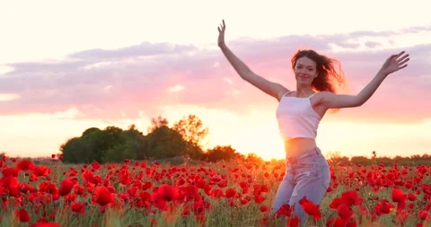 Beautiful young girl is jumping in flowe... | Stock Video | Pond5