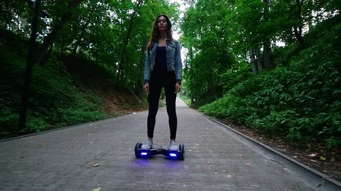 Beautiful young girl rides a gyro on a p... | Stock Video | Pond5