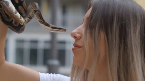 Beautiful young woman kissing a snake in... | Stock Video | Pond5