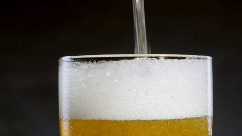 beer pouring into a glass on a black bac... | Stock Video | Pond5