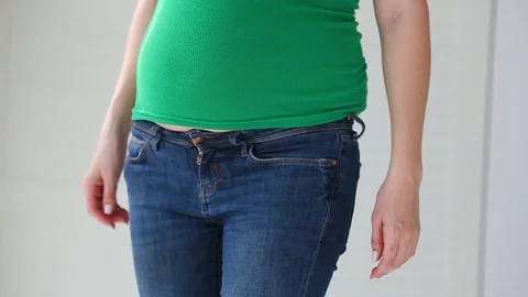 Belly of a female bulging out of jeans ... | Stock Video | Pond5