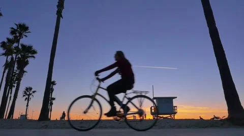 Bicyclists cycle at sunset as silhouette... | Stock Video | Pond5