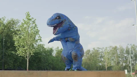 Big blue dinosaur dancing outdoors at su... | Stock Video | Pond5