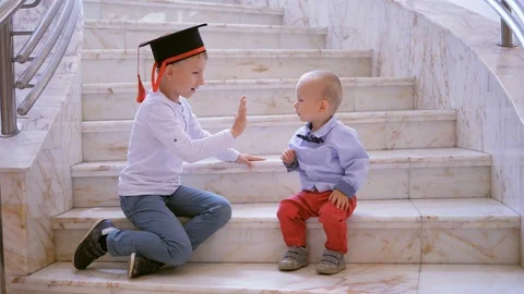 Bigger child with graduation cap giving ... | Stock Video | Pond5
