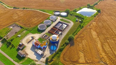 Biogas plant from pig farm in ripe wheat... | Stock Video | Pond5