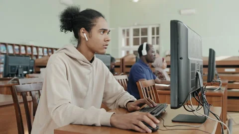 Black Boy Using Computer In Library | Stock Video | Pond5