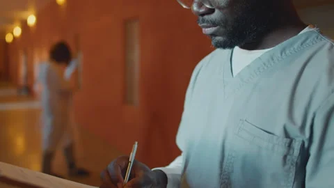 Black Doctor Making Notes In Medical Rec... | Stock Video | Pond5