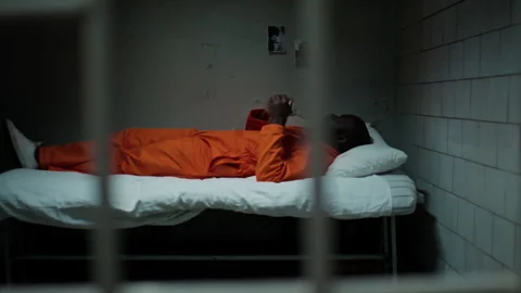 Black Inmate Lying on Bed in Prison Cell | Stock Video | Pond5
