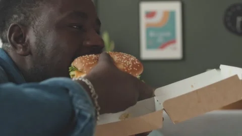 Black Man Eating Burger during House Par... | Stock Video | Pond5